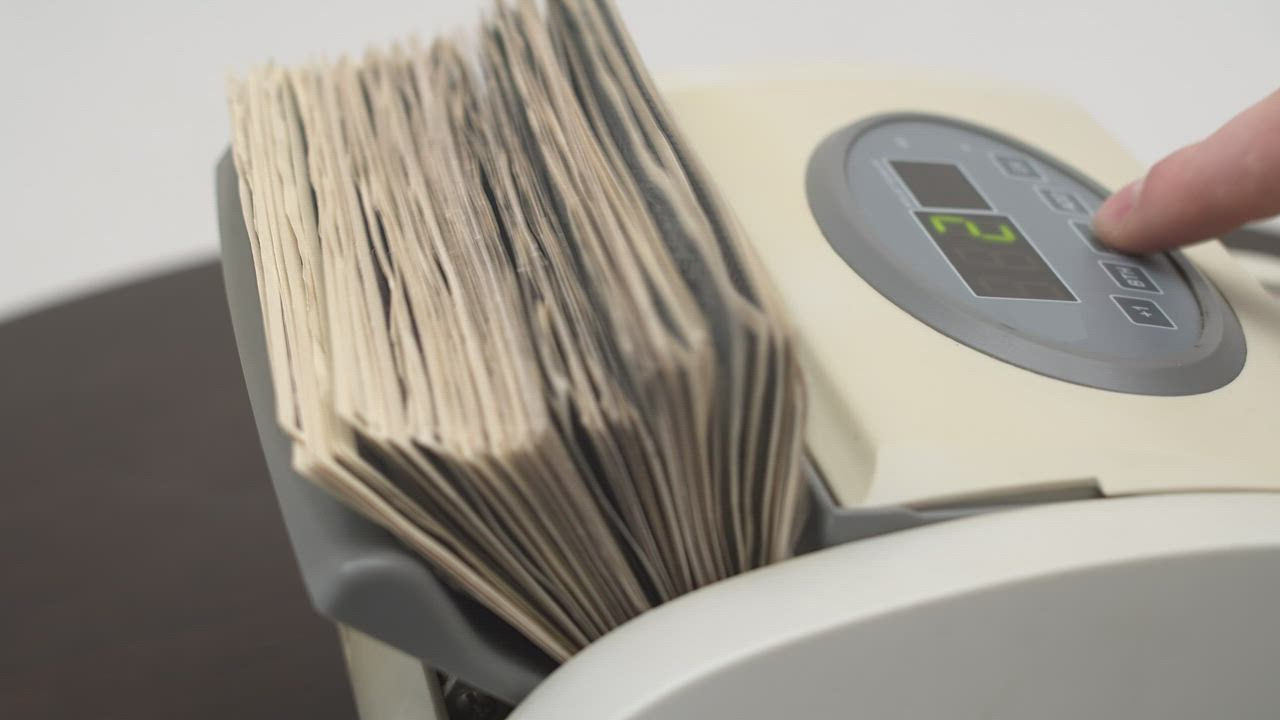 Money counting machine counting a stack of bills - Free Stock Video