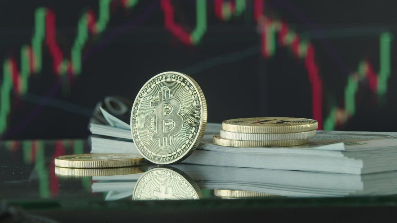 Bitcoin and cash sitting in front of a stock chart - Free Stock Video
