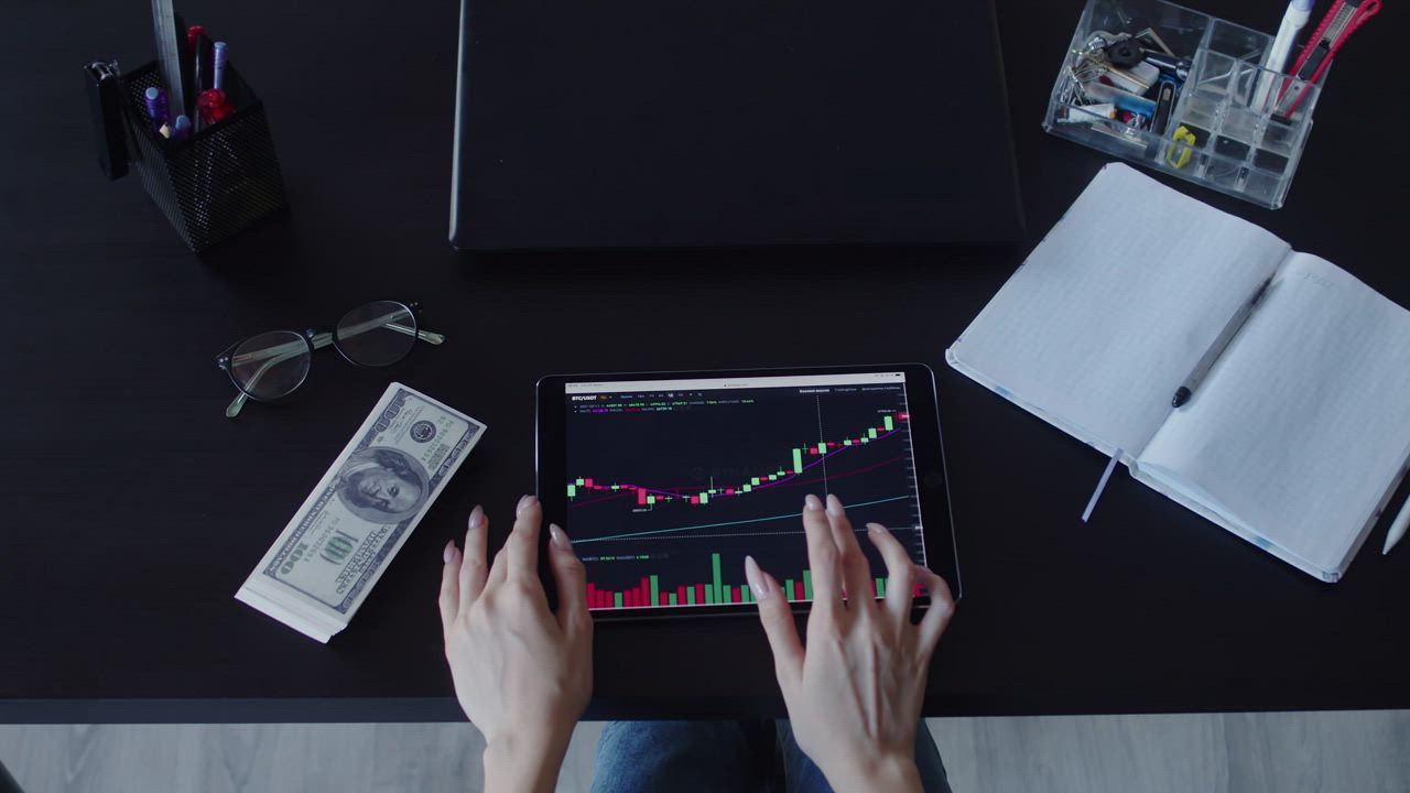 Investor checking stock charts on a tablet at the office - Free Stock Video