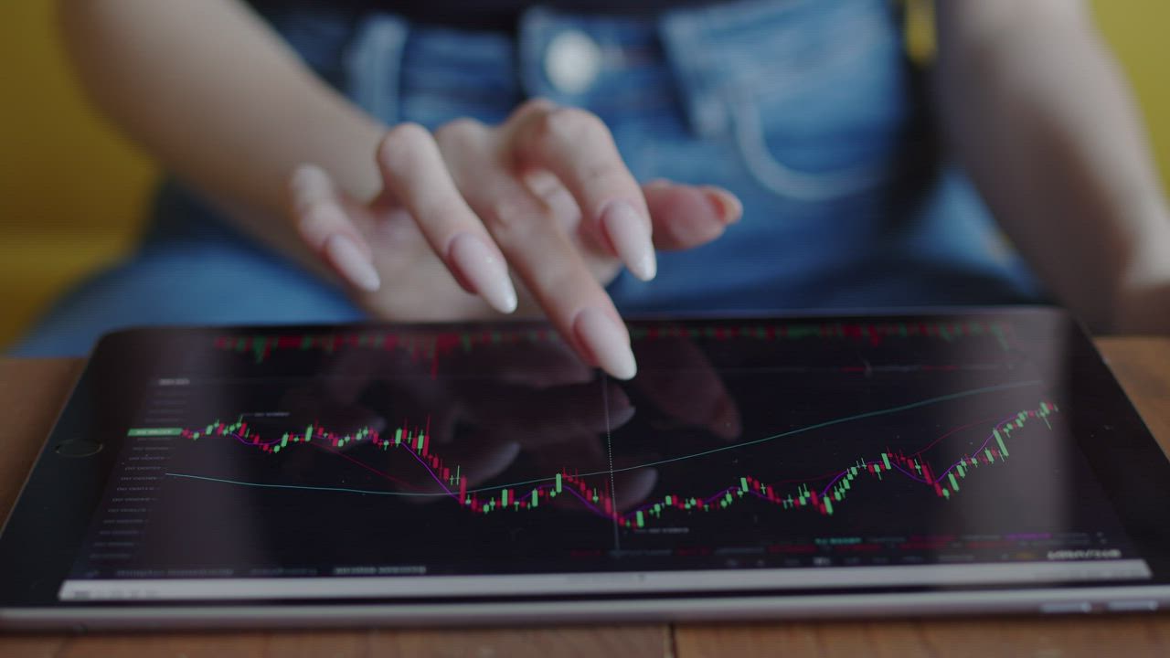 Investor checking stock prices on a tablet screen - Free Stock Video