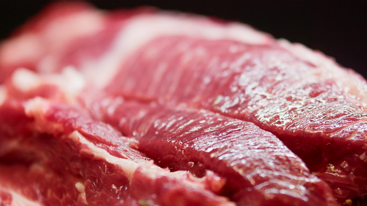 Close up of a raw cut of beef about to be cooked - Free Stock Video