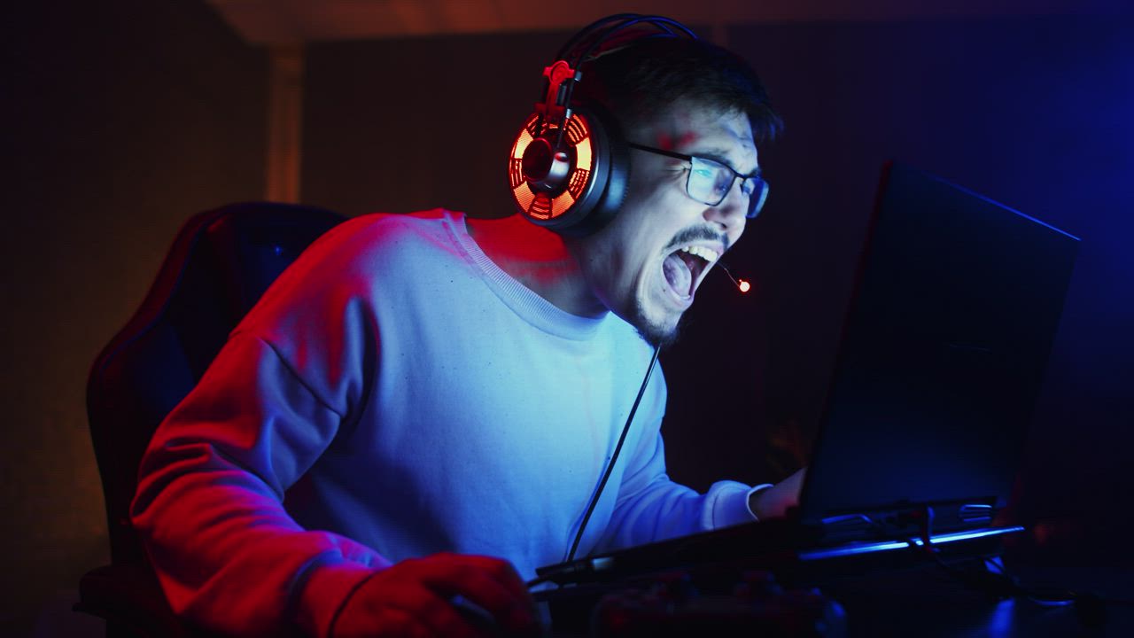 Frustrated gamer yelling at the screen in the dark - Free Stock Video