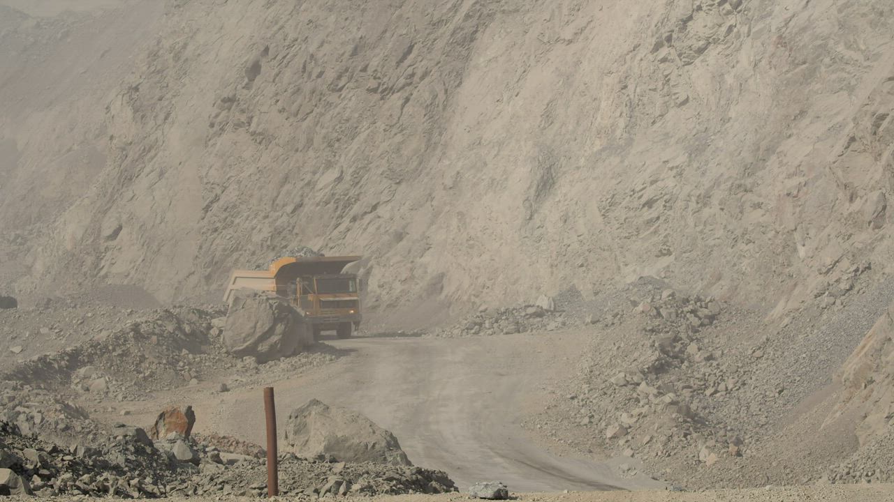 A loaded truck driving through a dusty mining quarry - Free Stock Video