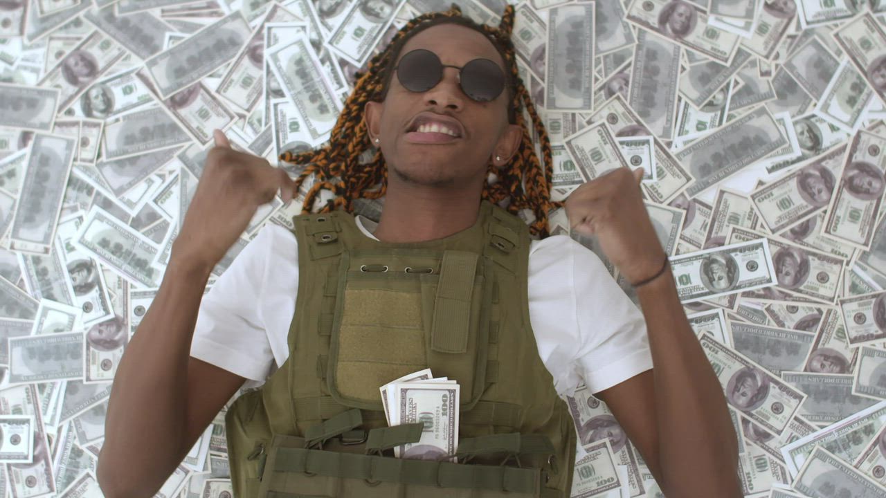 Rapper lying on the ground surrounded by money - Free Stock Video