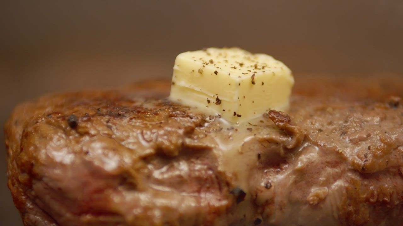 A nob of butter belting on top of a hot, juicy steak - Free Stock Video