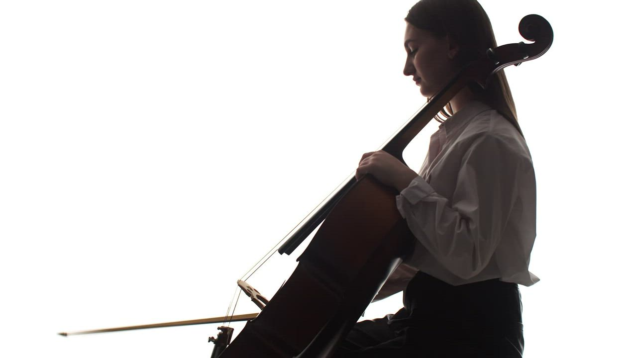 Side profile of a student playing the cello against a white background ...