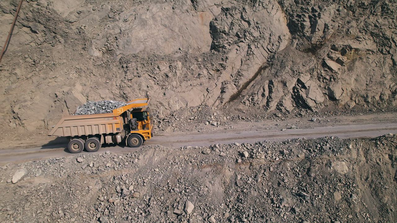 Large truck carrying a load of rubble up a mining site - Free Stock Video