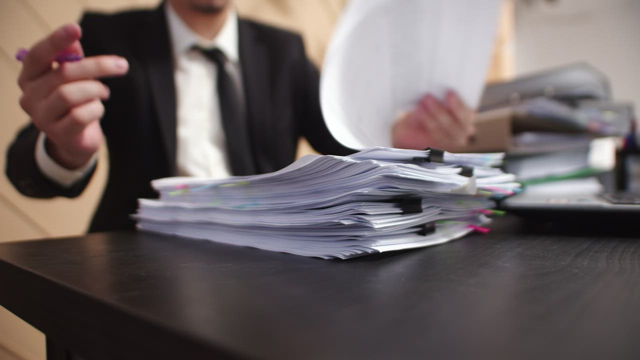 Close up of a tall stack of papers on a desk - Free Stock Video
