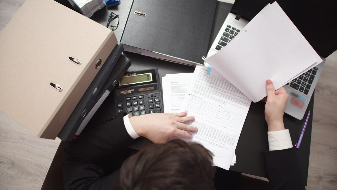 Birds eye view of an office worker busy at their desk - Free Stock Video