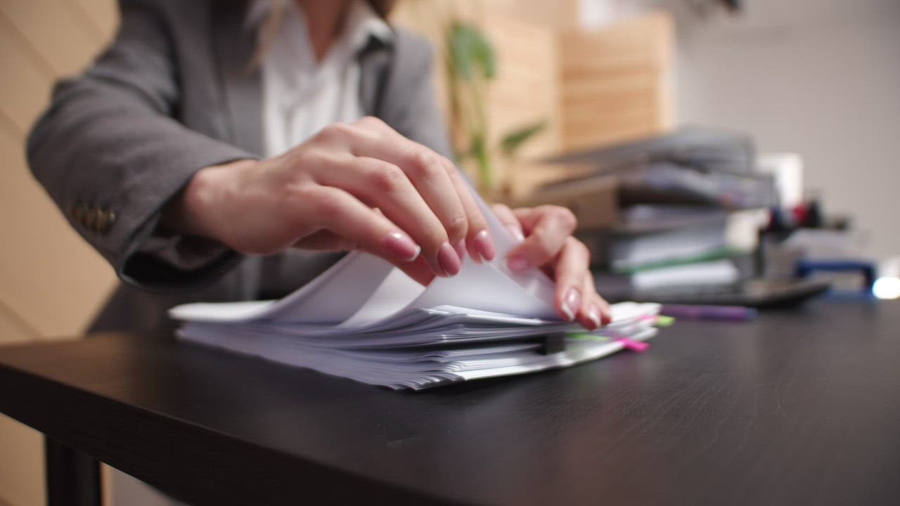 Close up of a business person flipping through paperwork - Free Stock Video