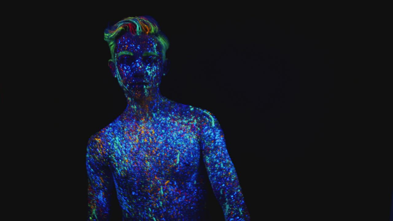 Man painted in fluorescent paint posing for the camera - Free Stock Video