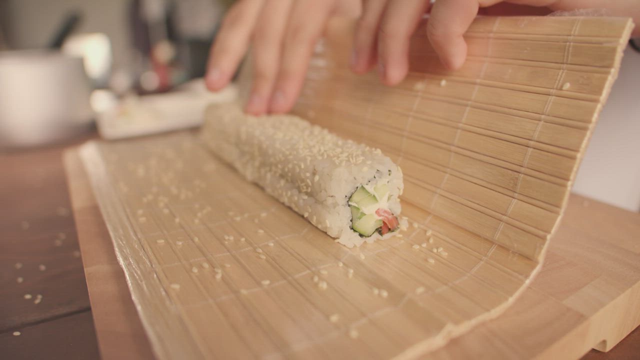 Sushi roll on a bamboo mat being prepared by a Chef - Free Stock Video