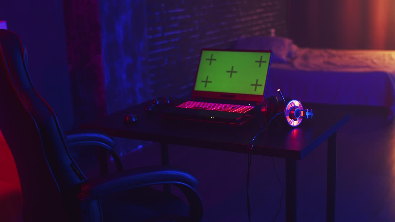 Gaming laptop green screen in a dark, dimly lit room - Free Stock Video