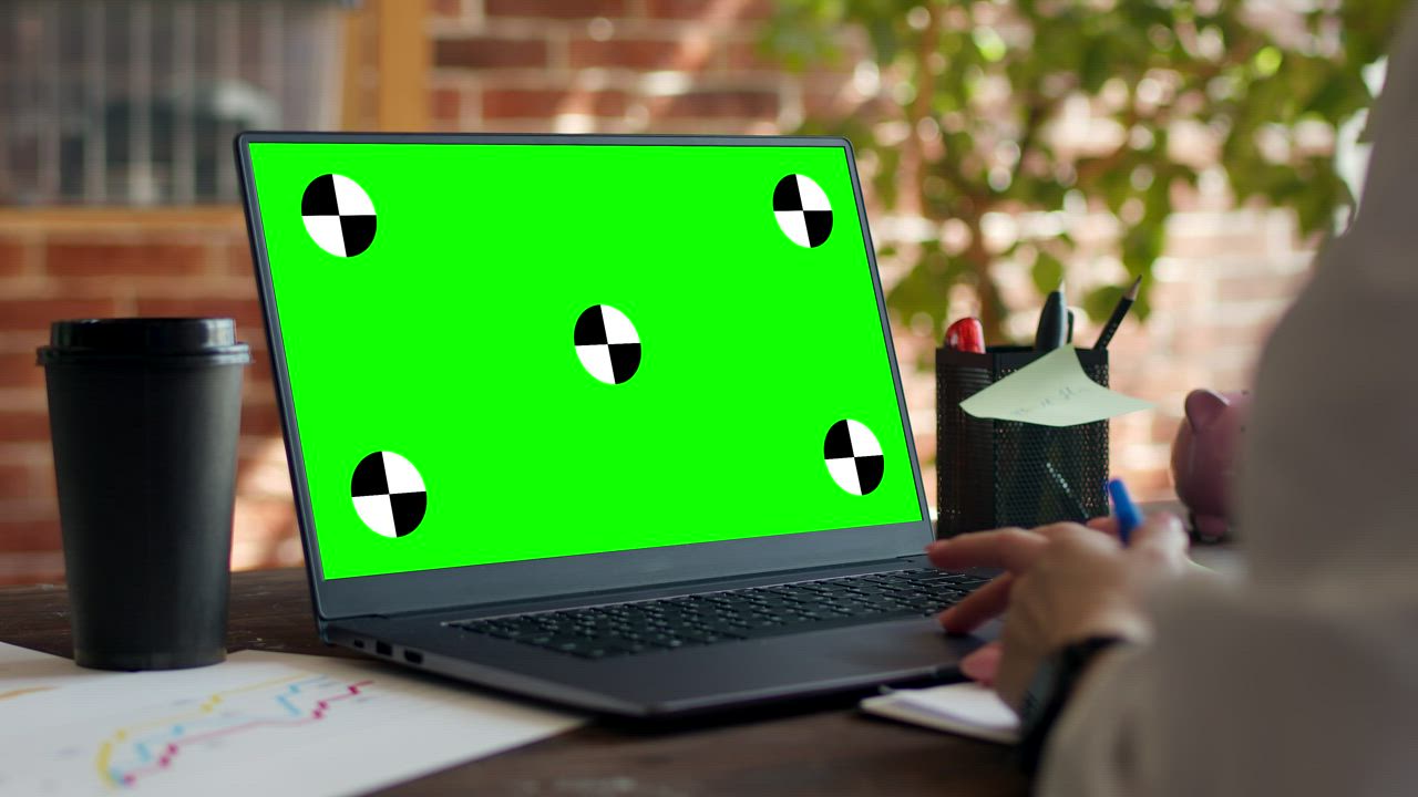 Close up of a laptop with green screen sitting on a desk - Free Stock Video