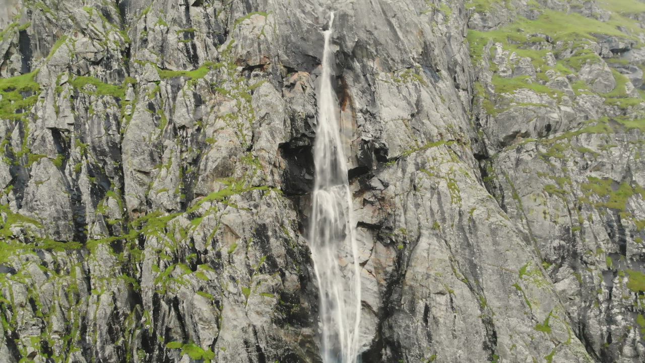 Aerial view of a waterfall falling over rocky cliffs - Free Stock Video