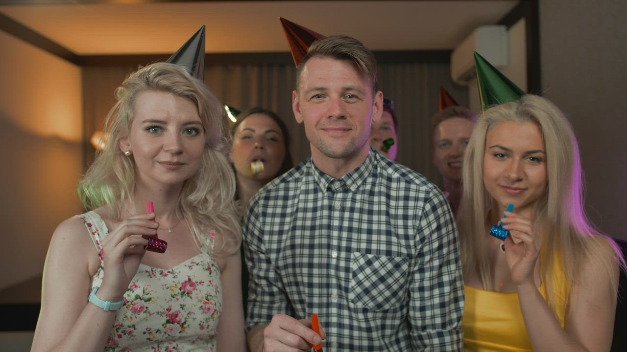 Excited young people partying with party hats - Free Stock Video