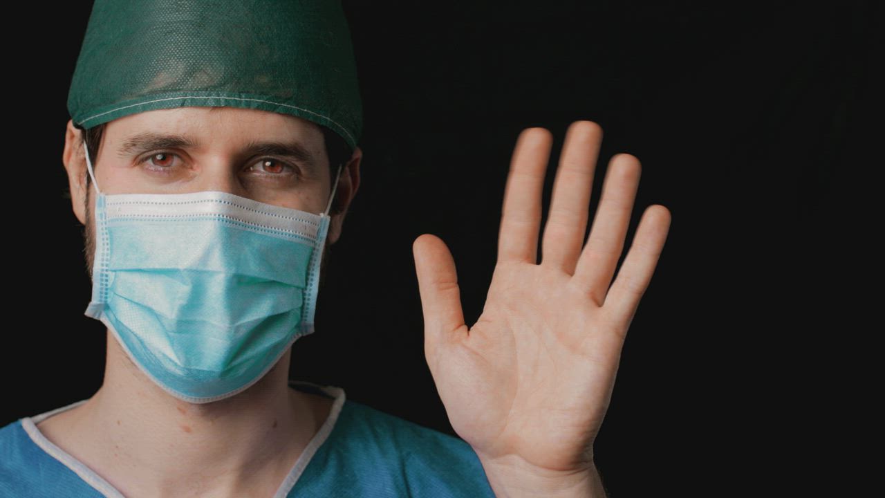 Close up of a doctor waving hello to camera - Free Stock Video