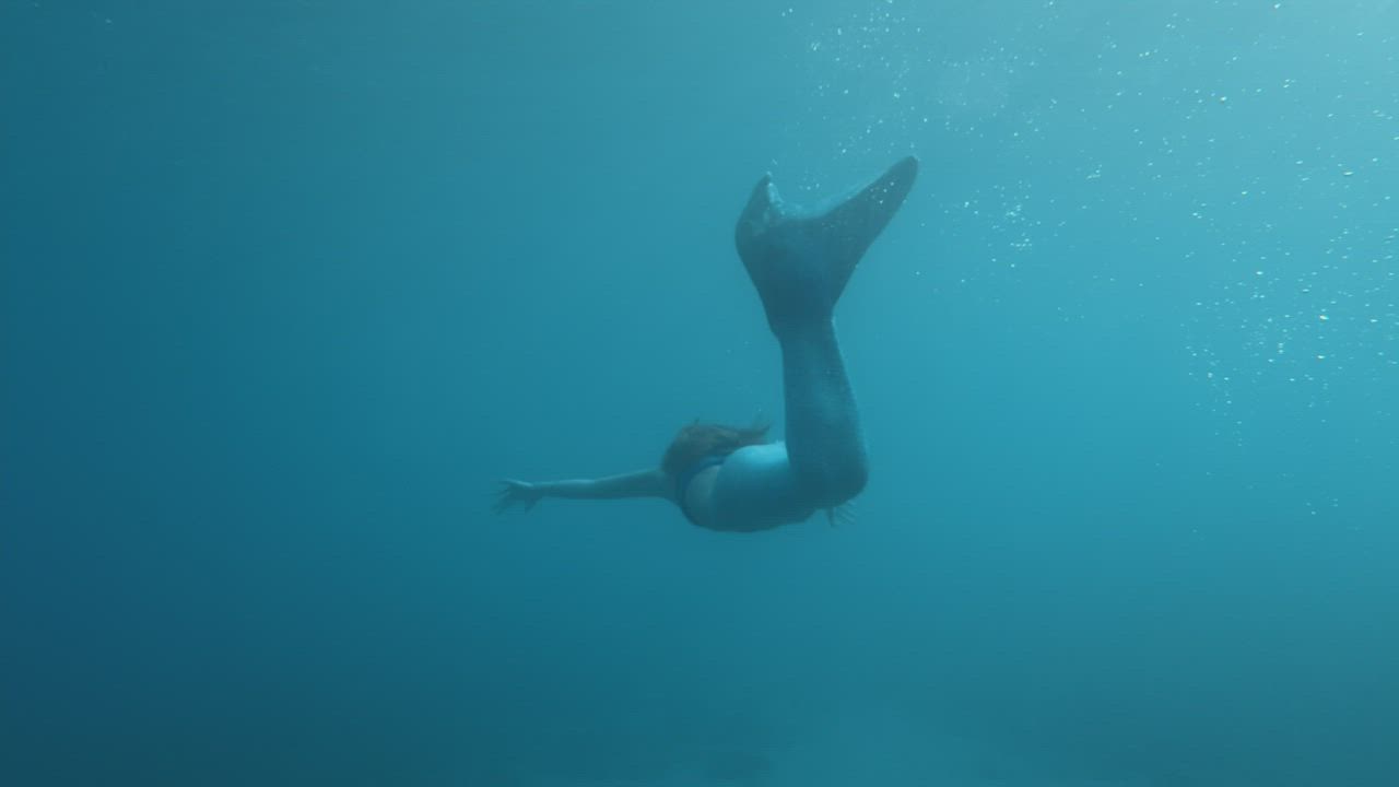 Mermaid swimming in the deep blue sea - Free Stock Video