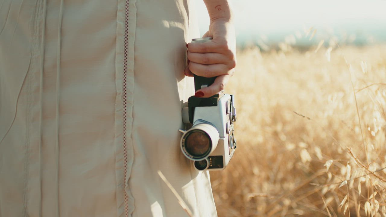 Hand holding a vintage film camera in the countryside - Free Stock Video