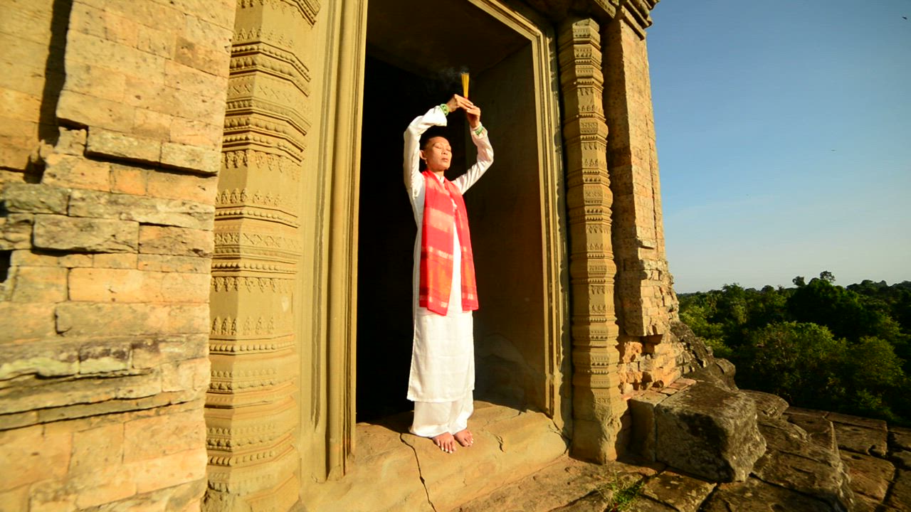 Woman praying at the entrance of a Buddhist temple - Free Stock Video