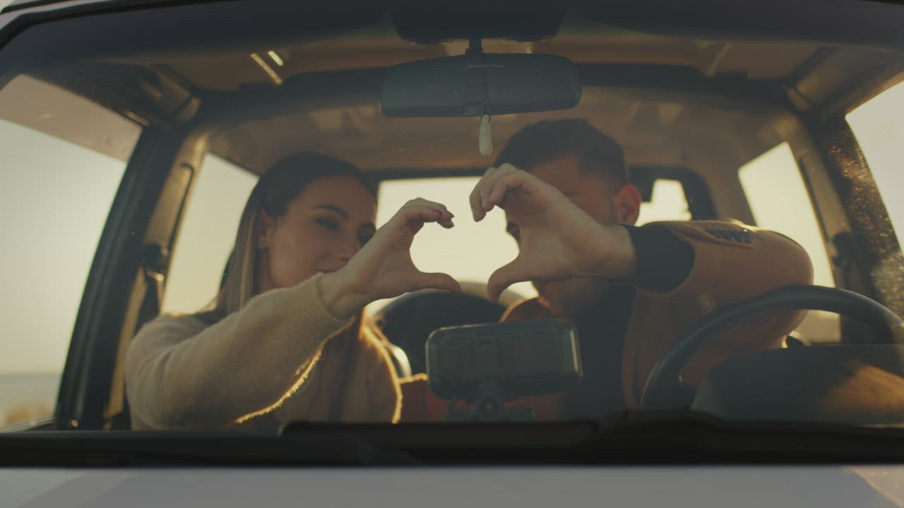 Couple sitting in a car making a heart sign with their hands - Free ...