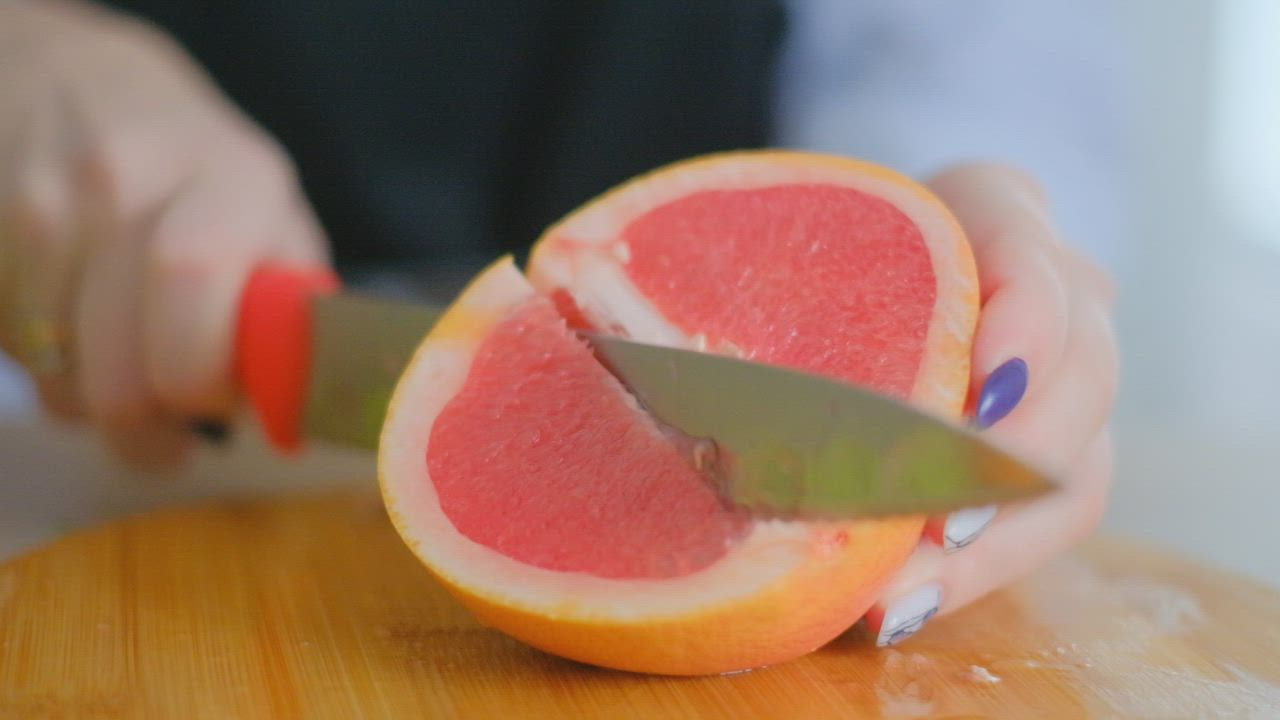 Closeup of cutting a grapefruit - Free Stock Video