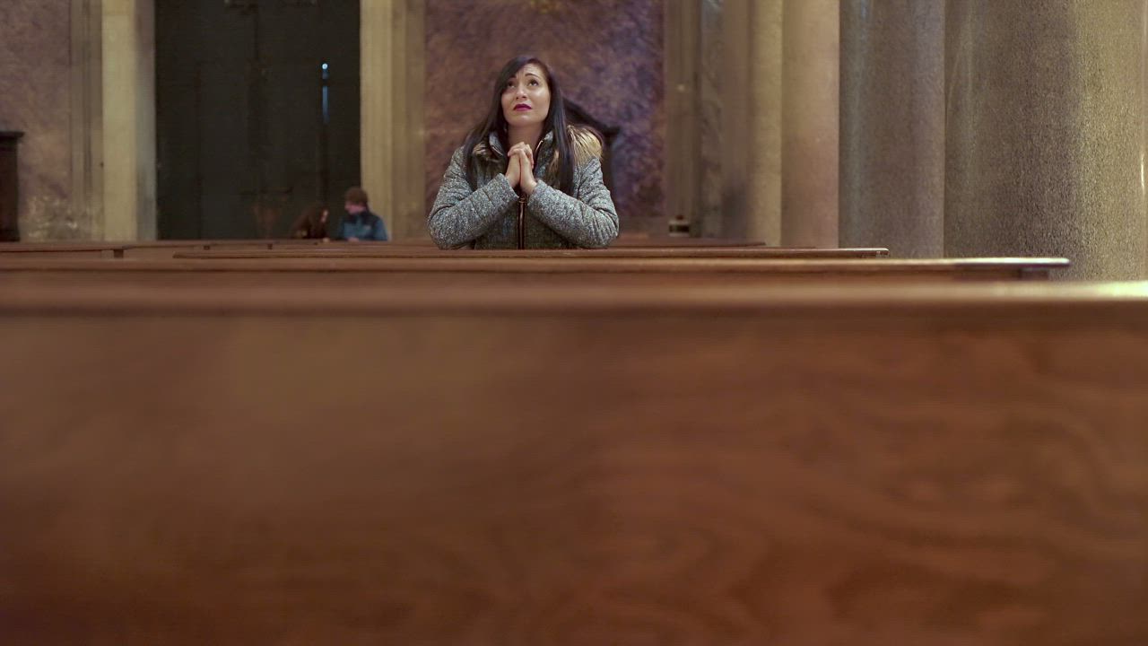 Upset woman praying in a church - Free Stock Video