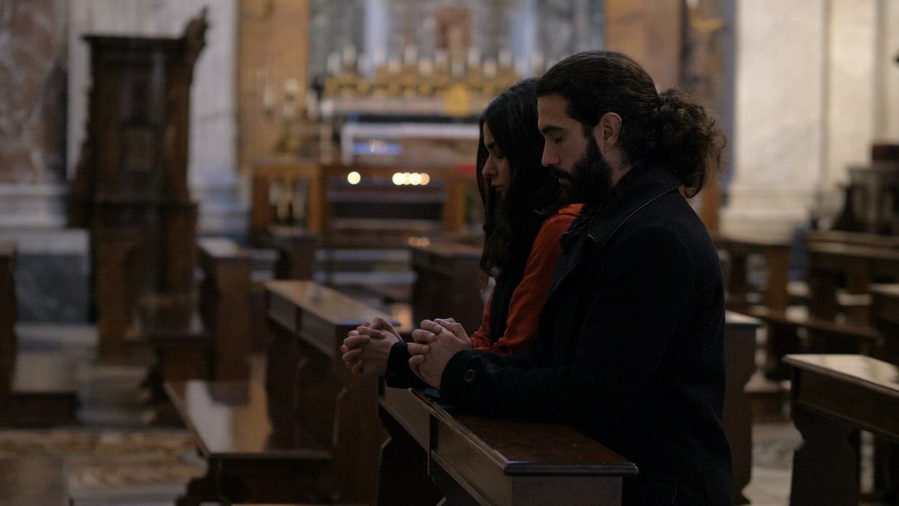 Couple at a church kneeling and praying - Free Stock Video