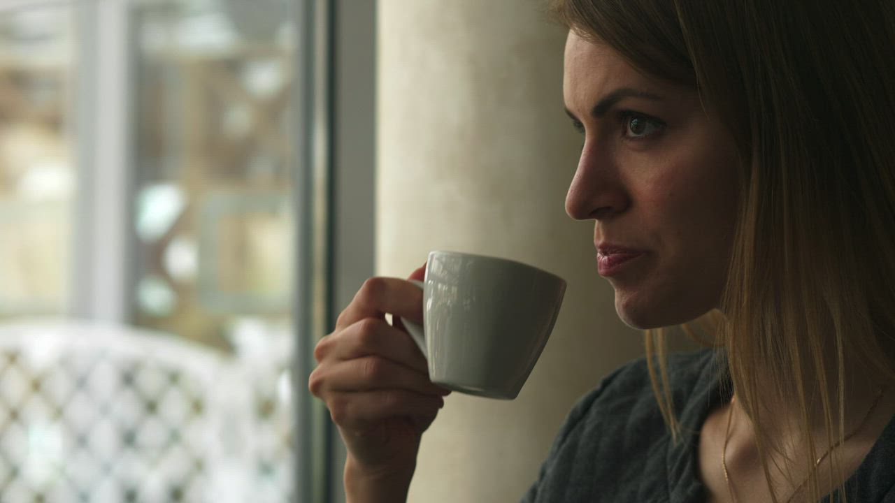 Woman sips from a coffee cup - Free Stock Video