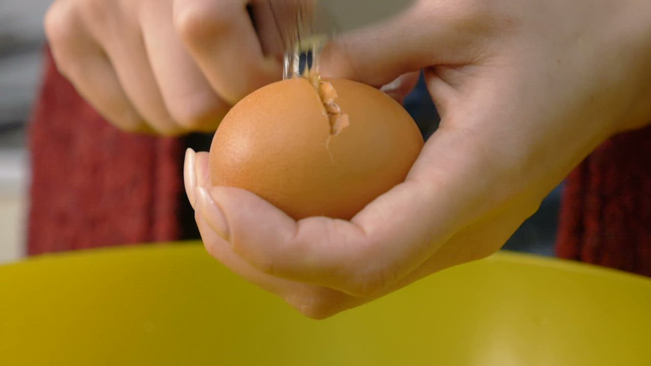 Person using a knife to break an egg shell - Free Stock Video