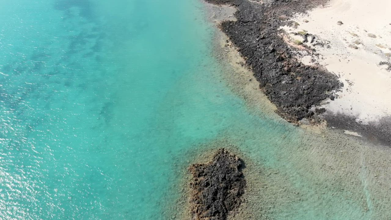 Aerial view of a crystal blue ocean - Free Stock Video