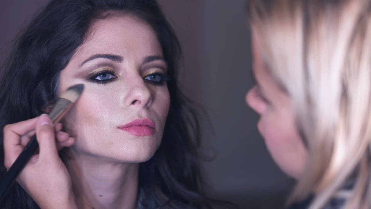 Make up artist applying foundation to a model - Free Stock Video