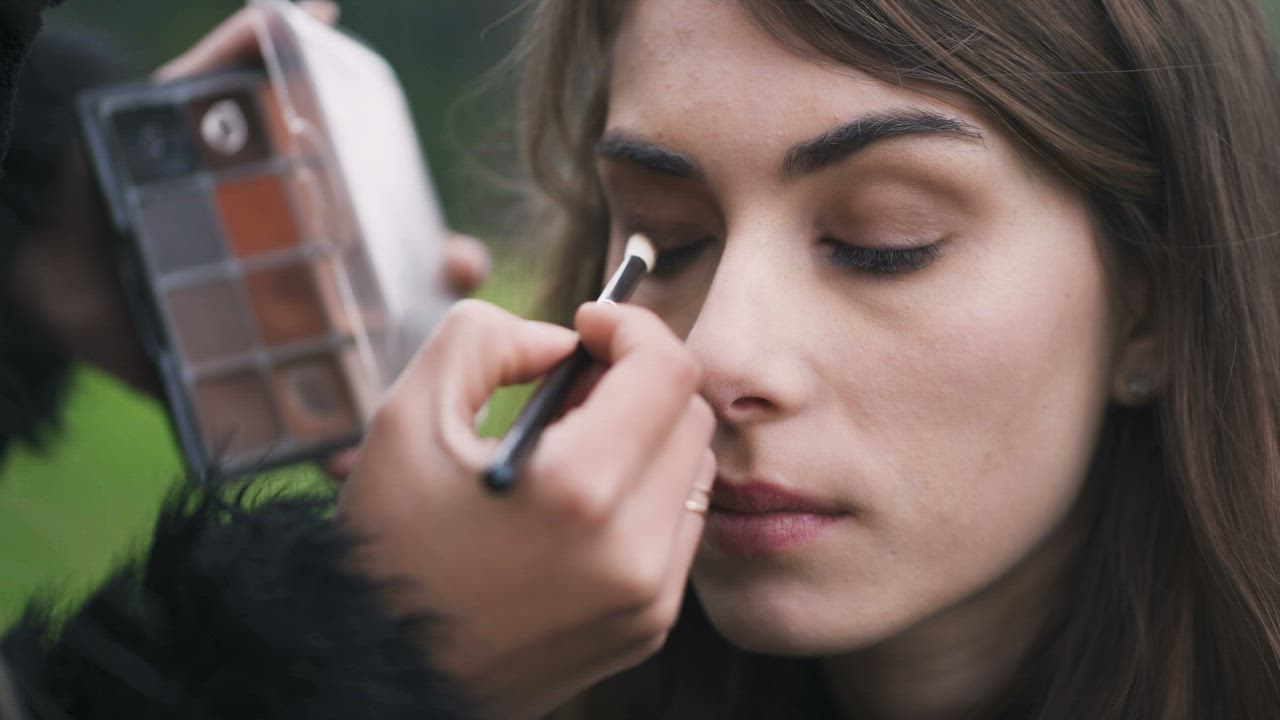 Model having eyeshadow applied by a make up artist - Free Stock Video
