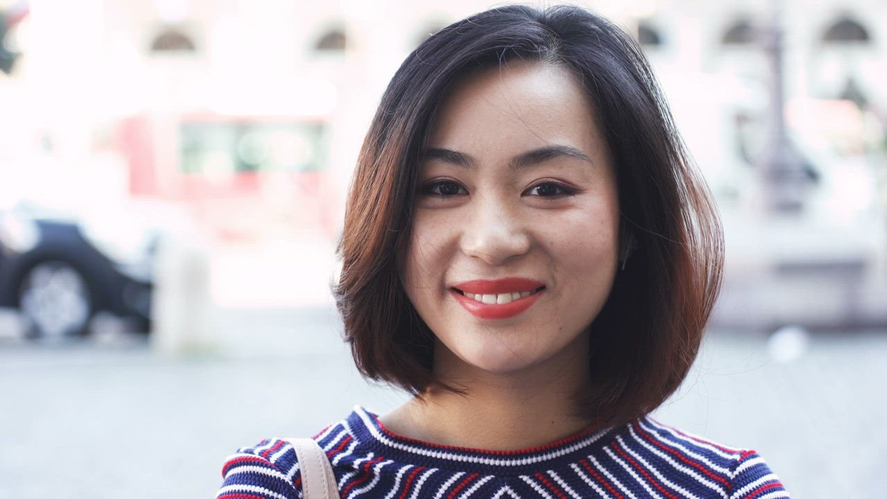 Woman looking straight at the camera with a small smile - Free Stock Video