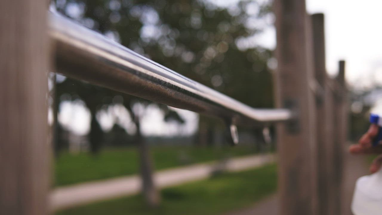 Close up of someone spraying and wiping public rails - Free Stock Video