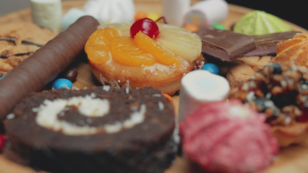 Little cake and candies on a rotating plate - Free Stock Video