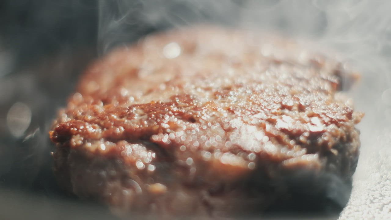 Close up of a frying piece of meat - Free Stock Video