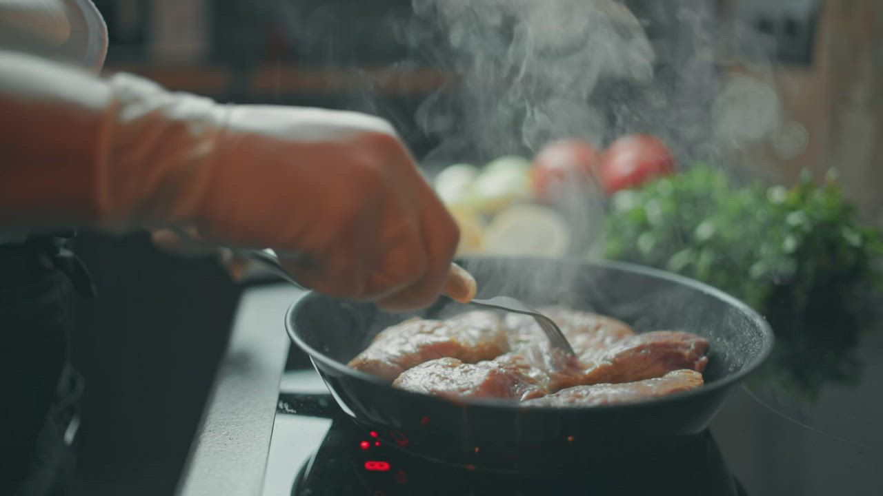 Frying pieces of meat in a pan with olive oil - Free Stock Video