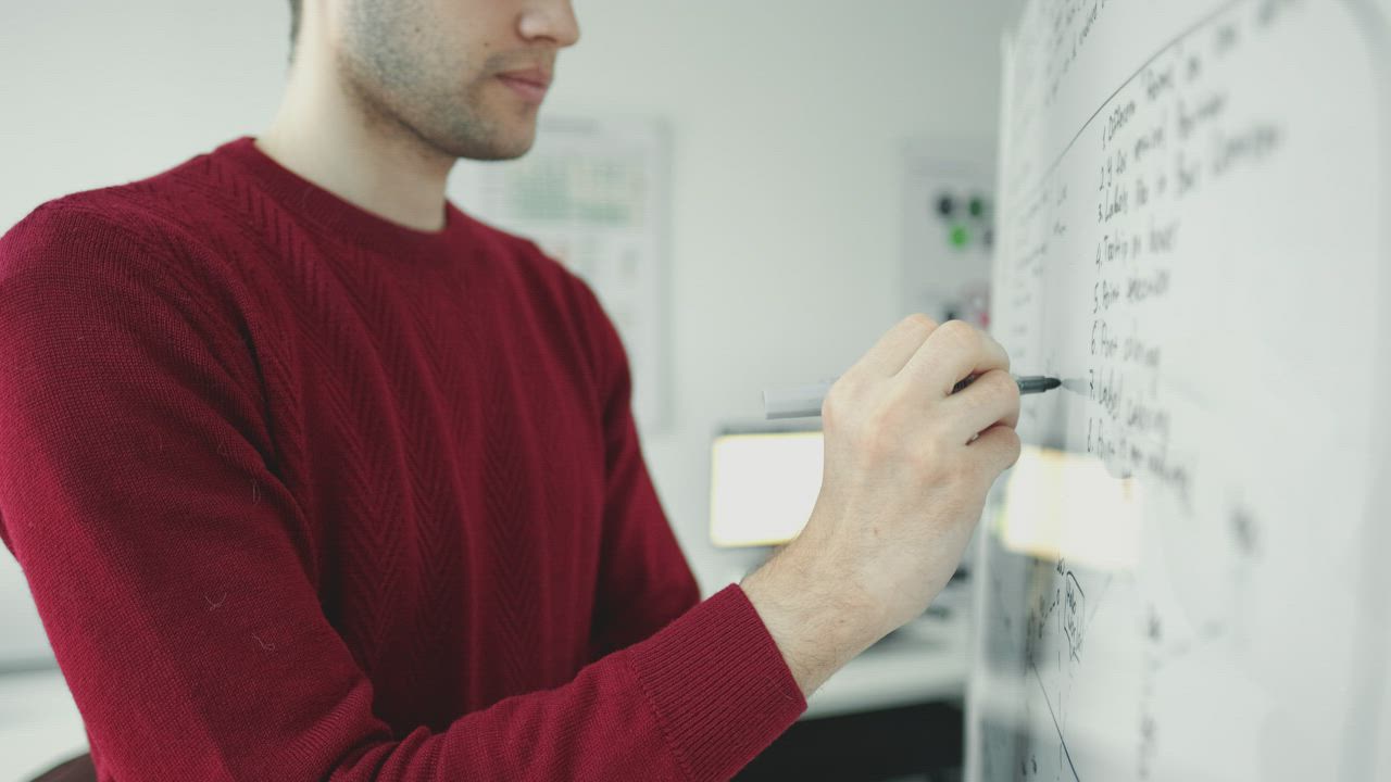 Man writing data on a whiteboard - Free Stock Video