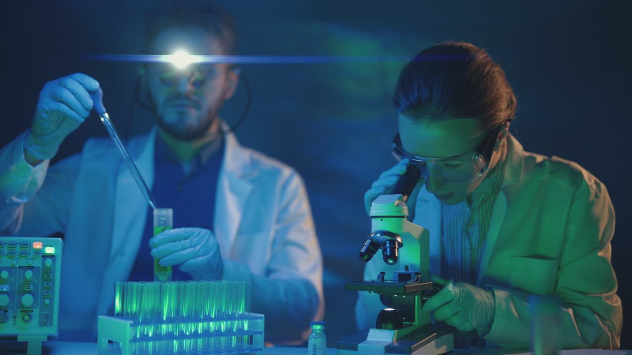 Zoom out of scientists in a blue lab - Free Stock Video