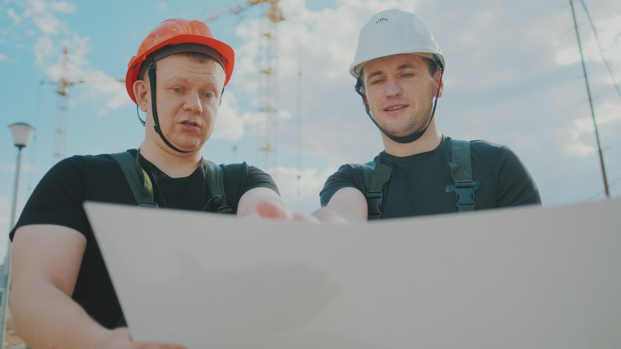 Civil engineers reading construction plans - Free Stock Video