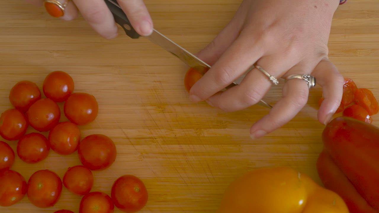 Close up of a chef chopping cherry tomoatoes - Free Stock Video