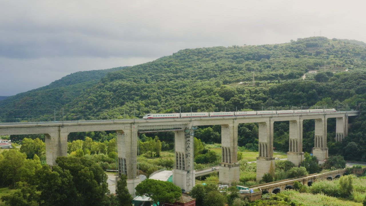 Train passes over a bridge in the middle of green valleys - Free Stock ...