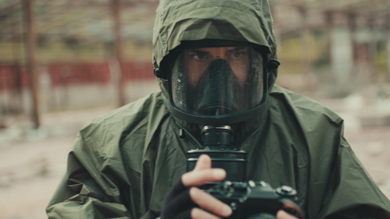 Military man in mask takes photos of the destroyed area - Free Stock Video