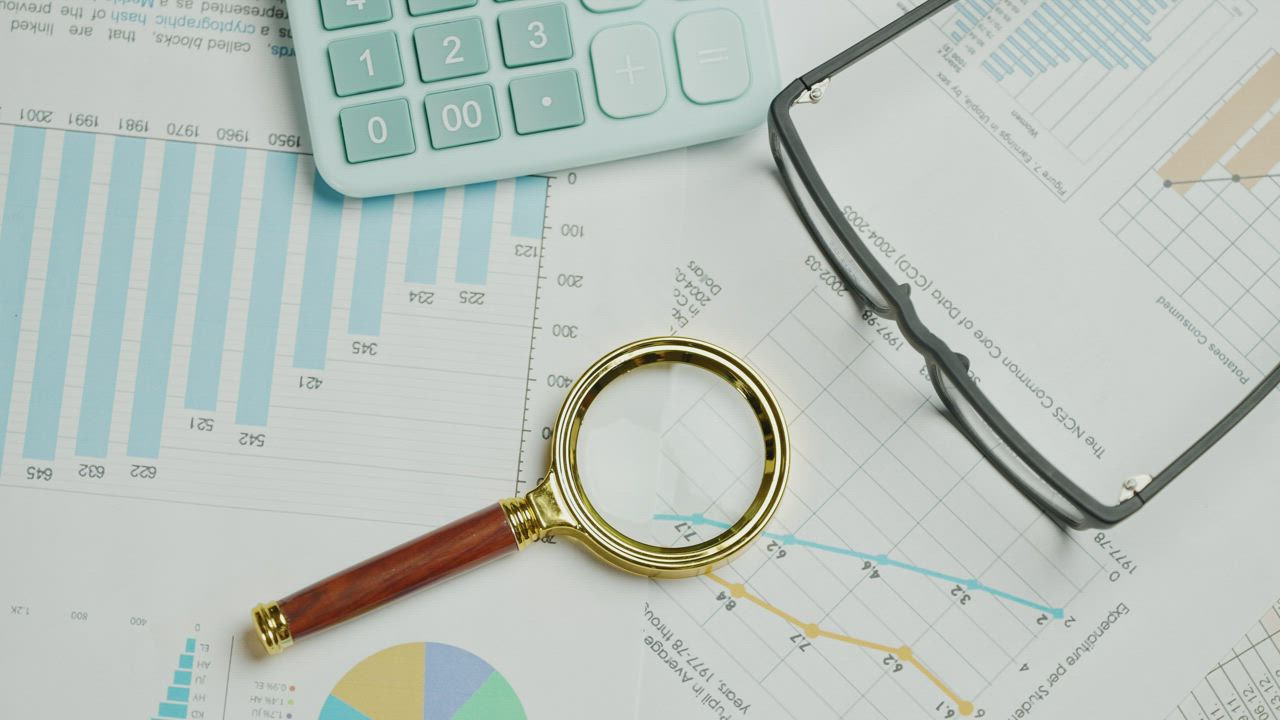 Documents with magnifying glass on a desk - Free Stock Video