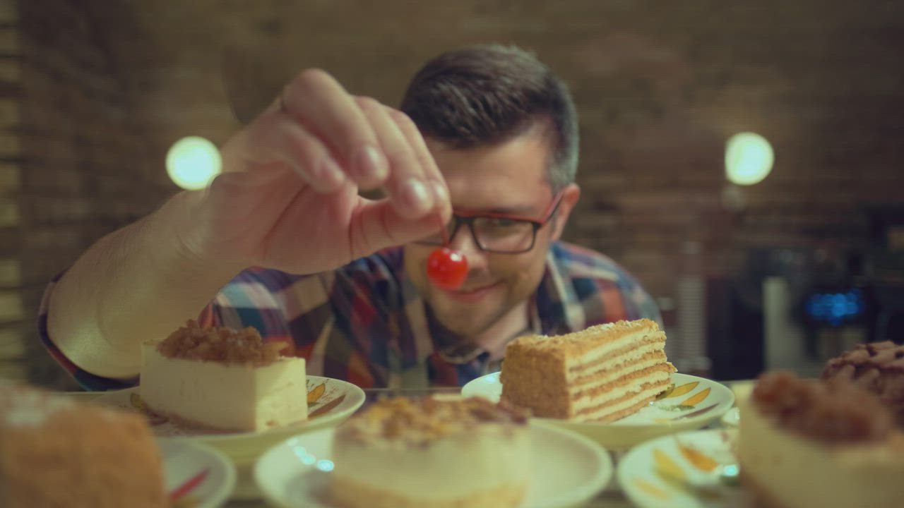 Man baker decorating a cake with a cherry on top - Free Stock Video