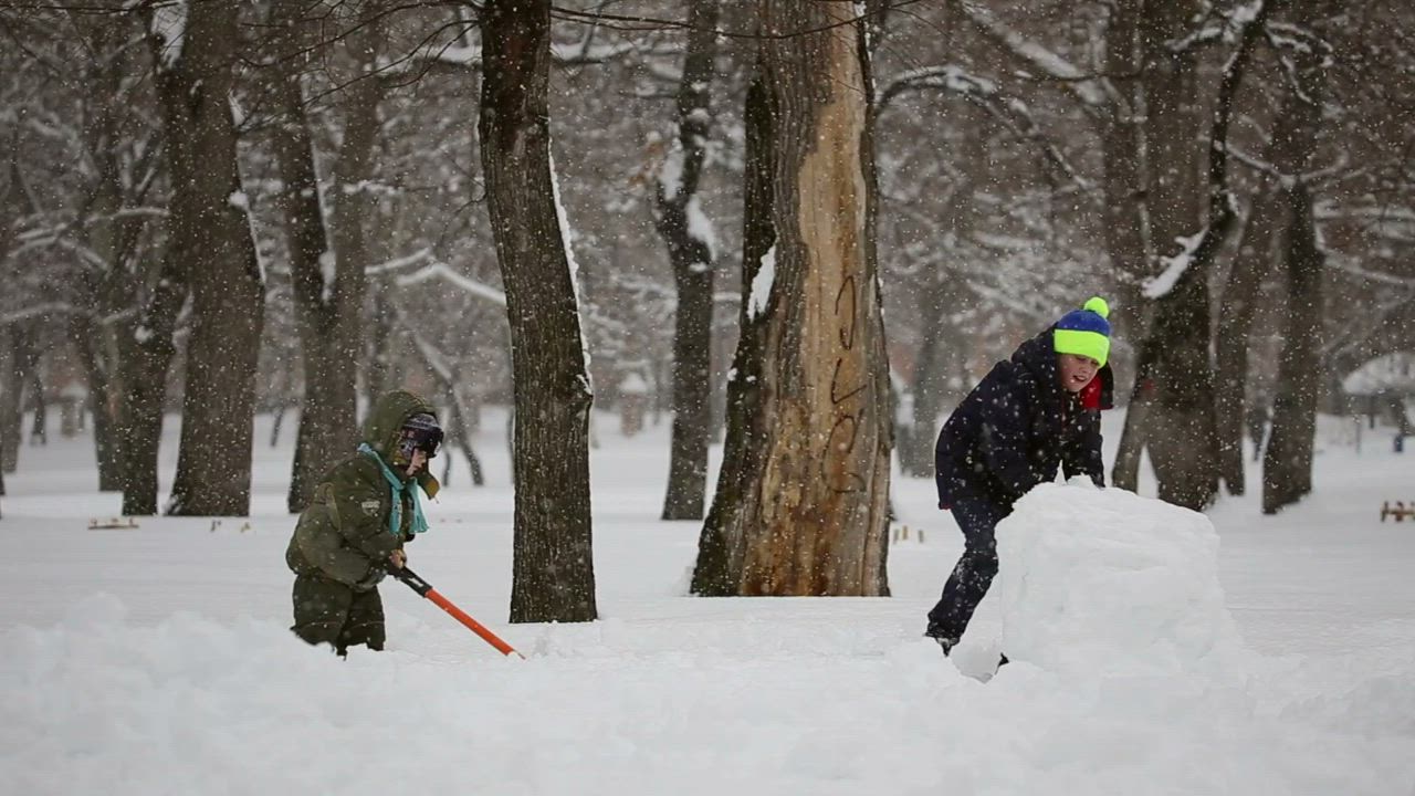 Family in the snow making snowman - Free Stock Video