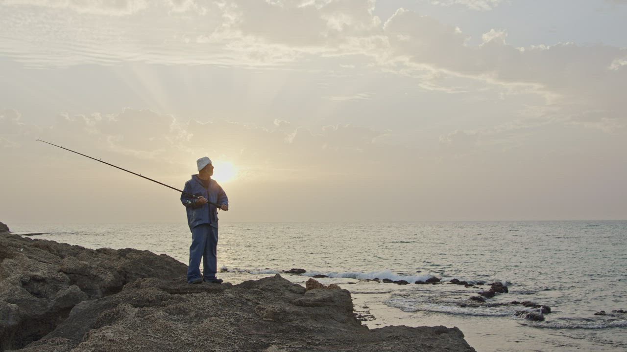 Fisherman fishing and standing on the seaside rocks at sunset - Free ...