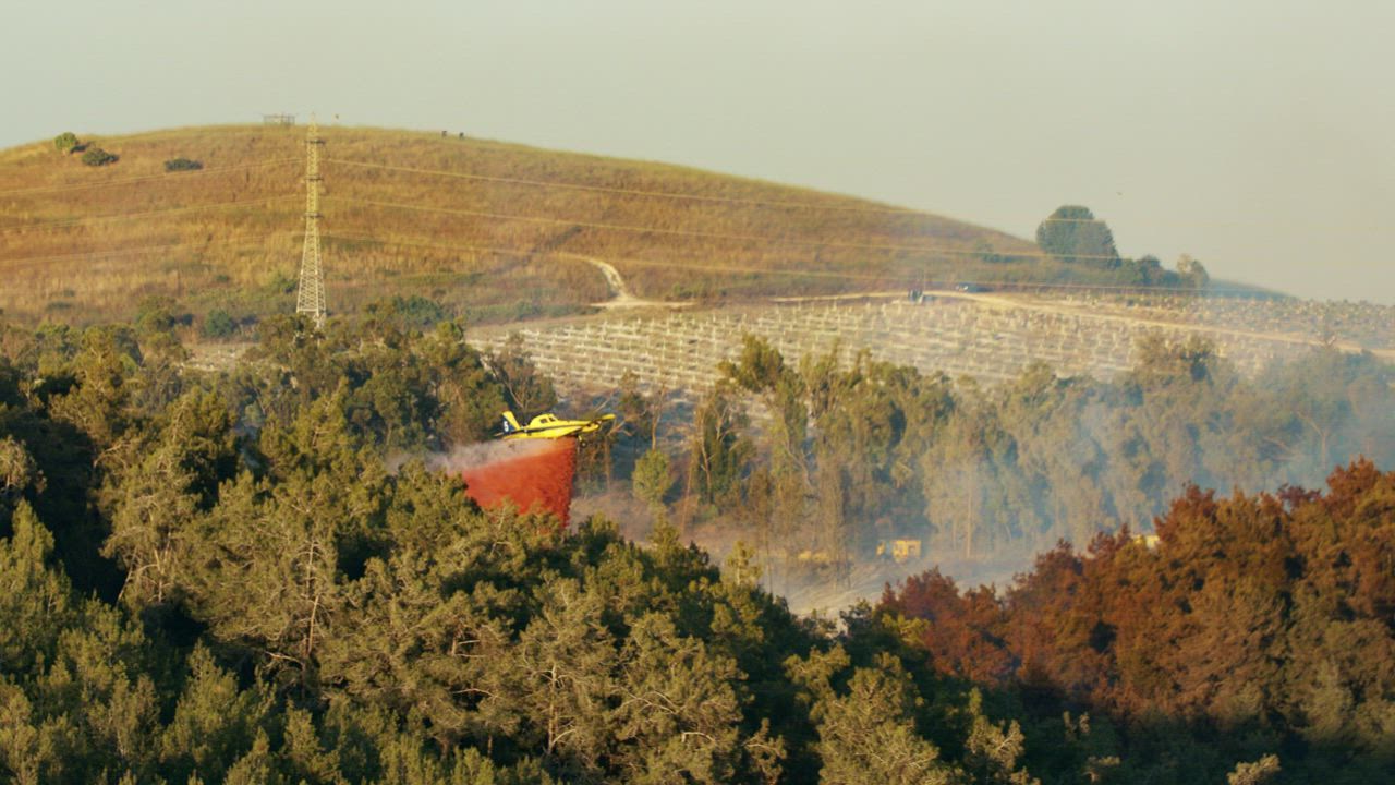 Aircraft sprays extinguisher powder to extinguish a fire - Free Stock Video