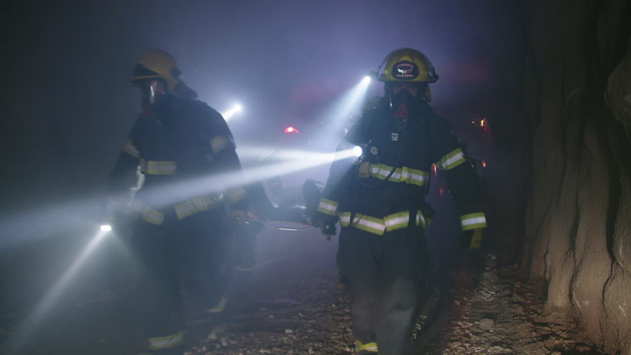 Rescue team searches for survivors inside a dark tunnel - Free Stock Video